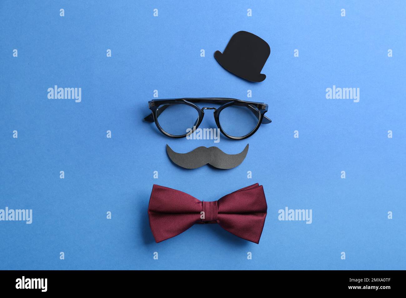 Flat lay composition with glasses and bow tie on blue background. Happy ...