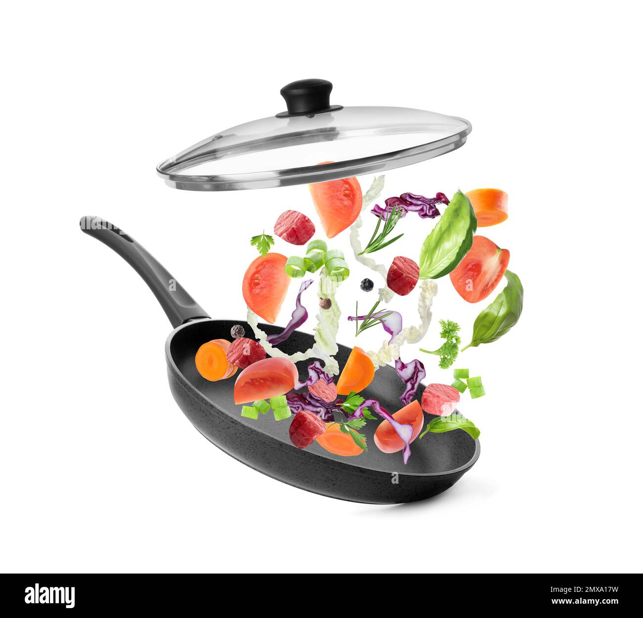 Different vegetables and beef slices falling into frying pan on white ...