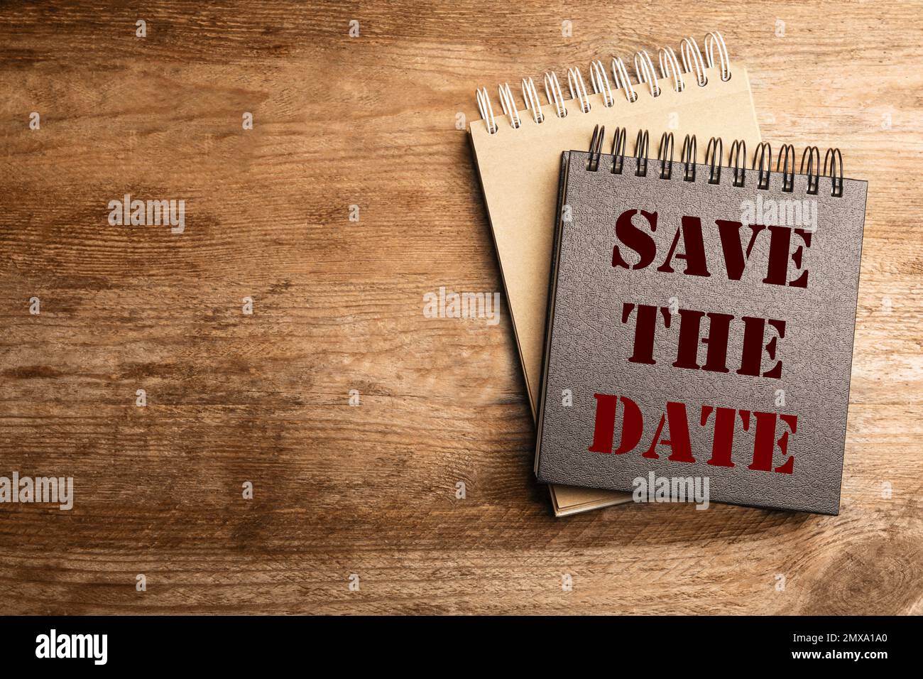 Stylish notebooks with phrase SAVE THE DATE on wooden table, top view ...