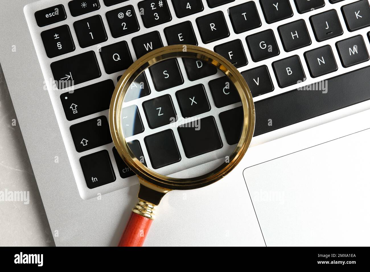 Magnifying glass and modern laptop on table, top view. Search concept ...