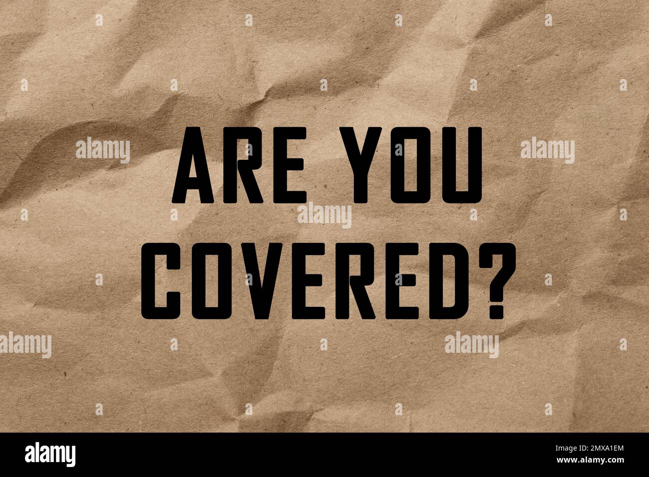 Text ARE YOU COVERED? on brown crumpled paper background. Insurance ...