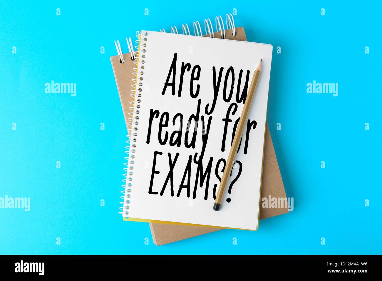 Notebooks with phrase ARE YOU READY FOR EXAMS and pencil on light blue ...