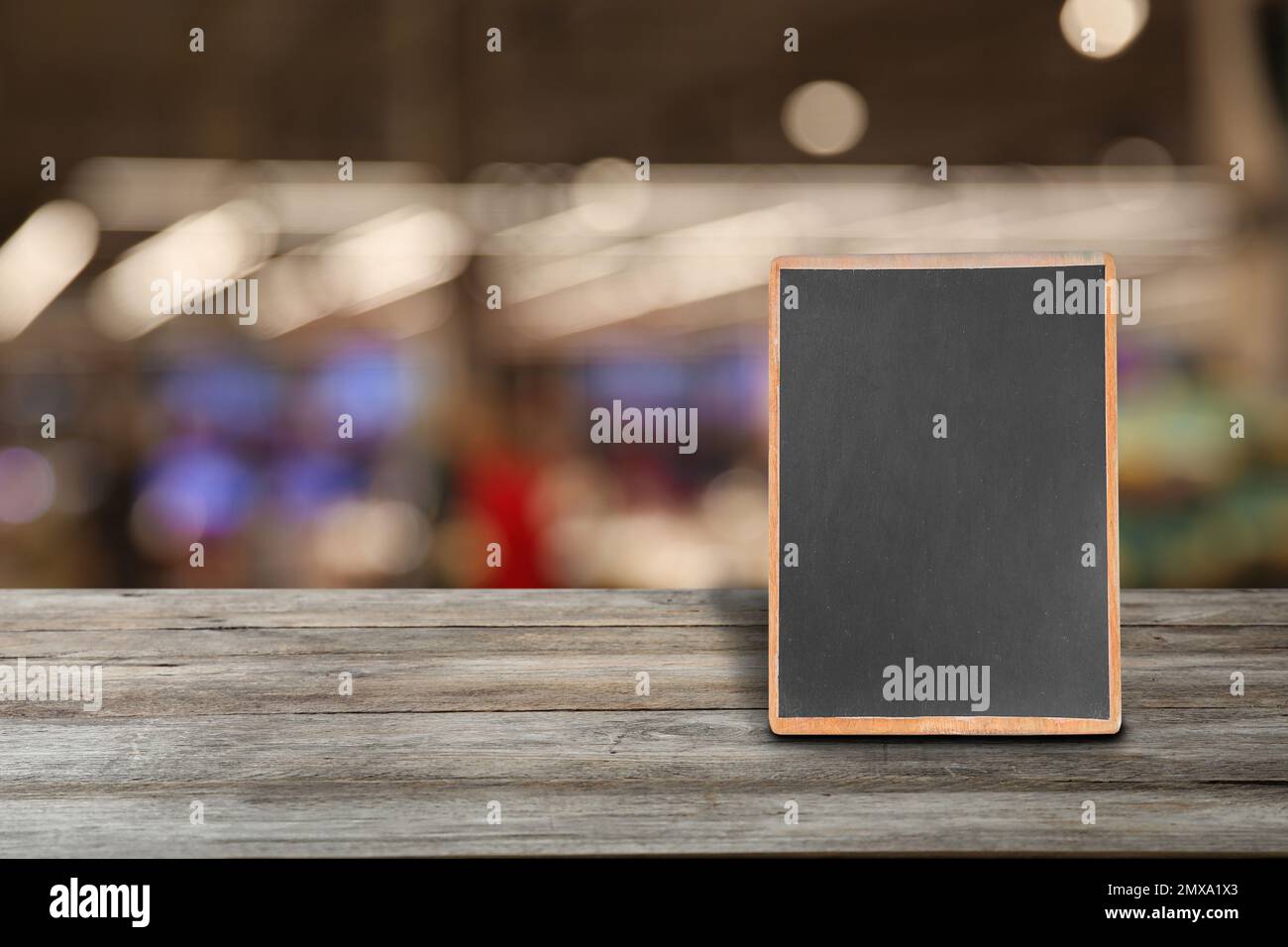 Blank small blackboard on wooden table in cafe, mockup for menu design ...