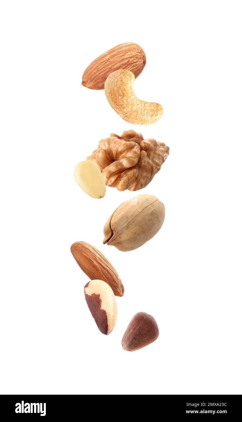 Different nuts falling on white background Stock Photo - Alamy