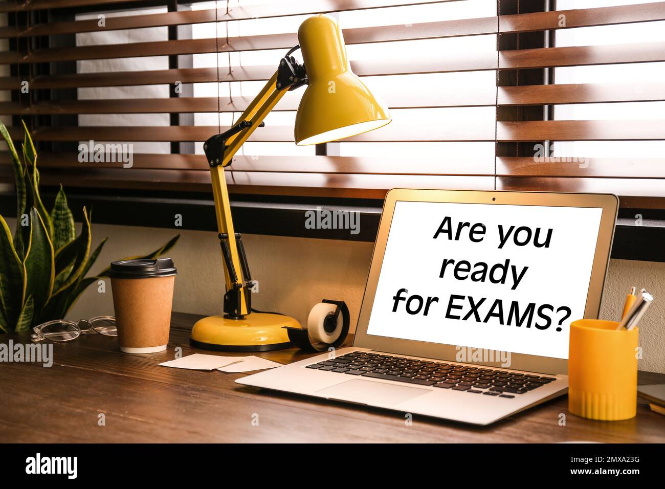 Modern laptop with phrase ARE YOU READY FOR EXAMS on table in office ...