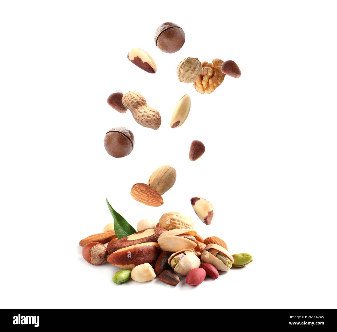 Different nuts falling into pile on white background Stock Photo - Alamy
