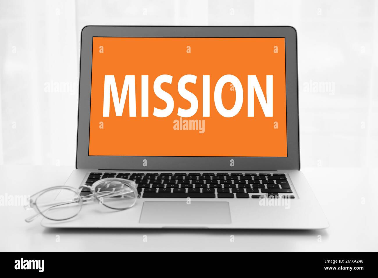 Modern laptop with word MISSION on screen indoors Stock Photo - Alamy