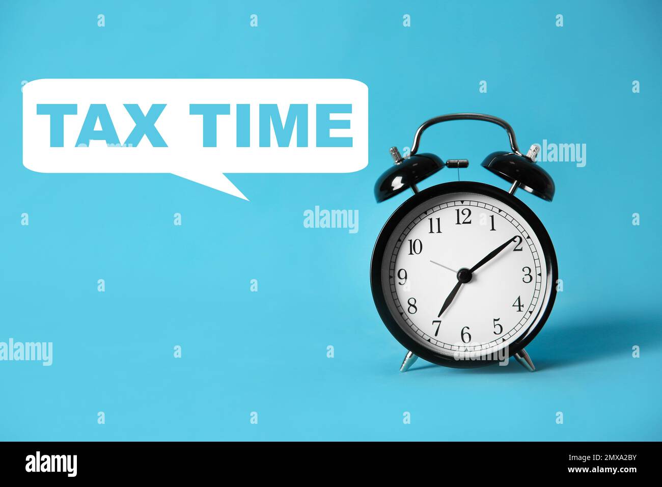 Time to pay taxes. Alarm clock on light blue background Stock Photo - Alamy
