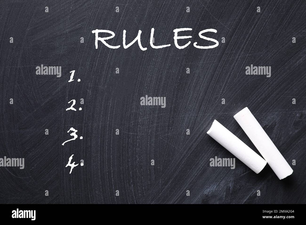 White chalk sticks on blackboard with list of rules, flat lay Stock ...