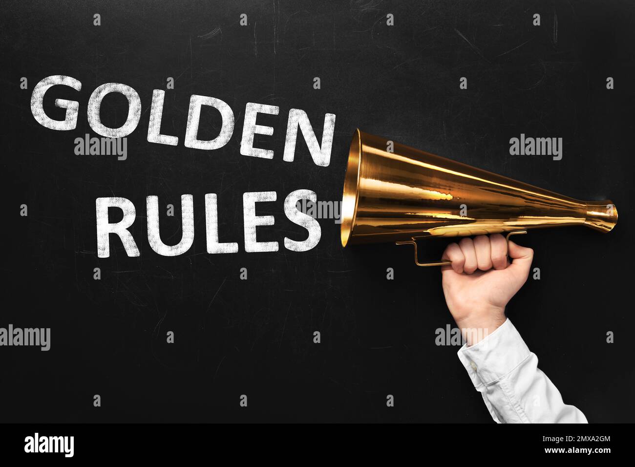 Man holding retro megaphone near chalkboard with phrase GOLDEN RULES ...
