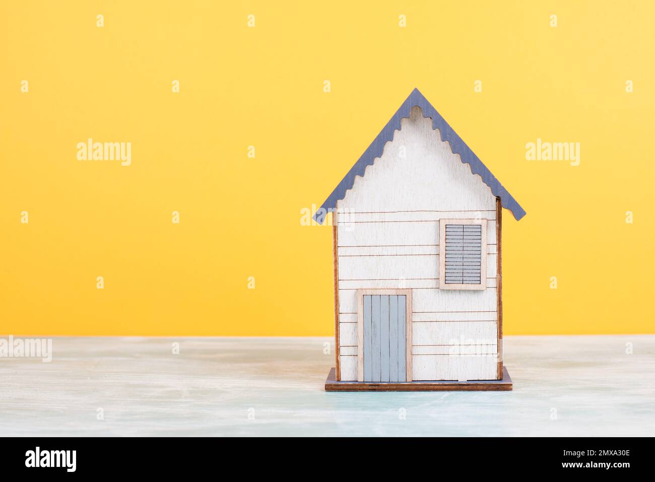 Wooden house, yellow background, buying or renting a house, real estate ...