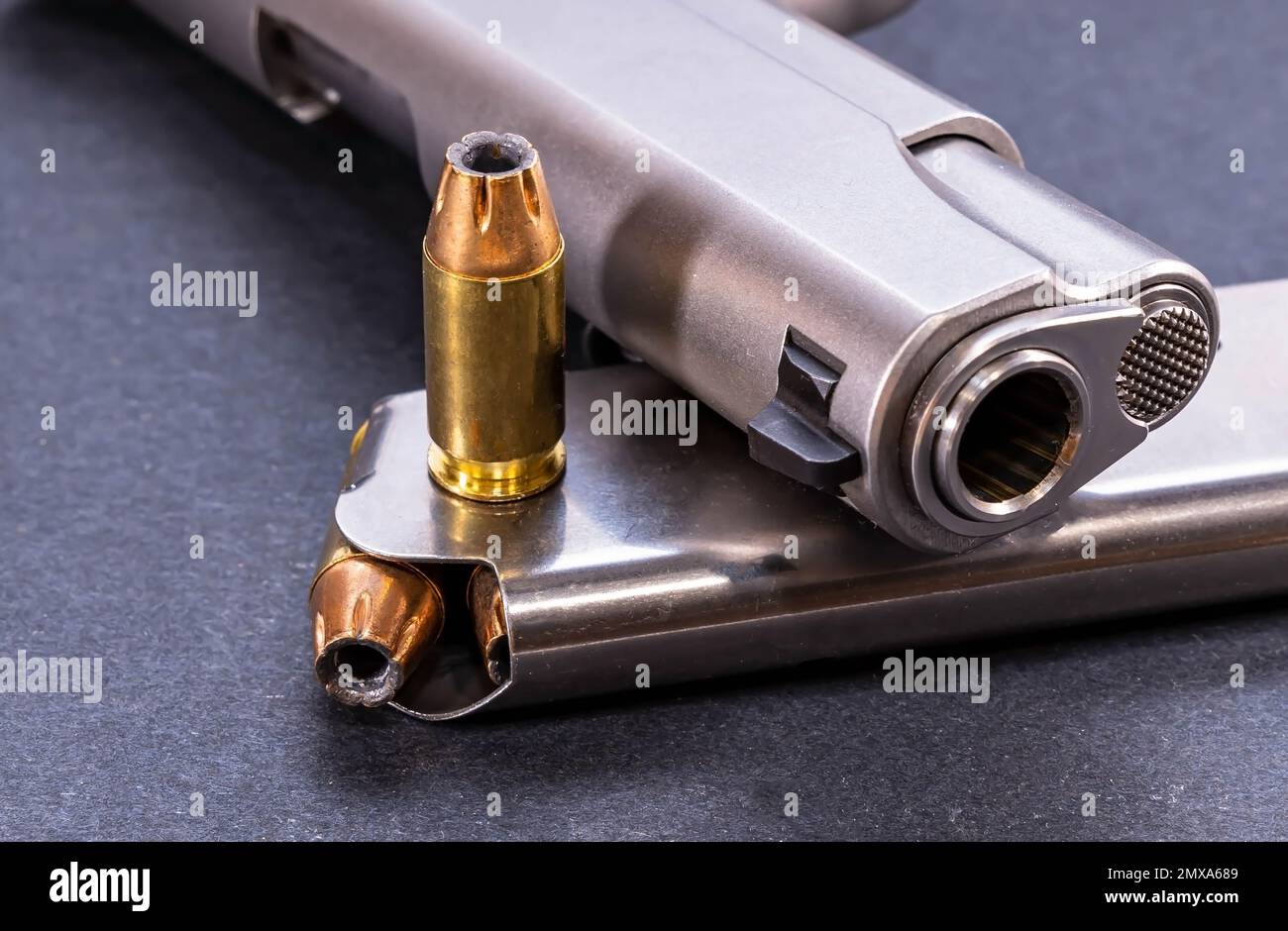 A stainless steel 1911, 45 ACP pistol with a loaded magazine and an ...