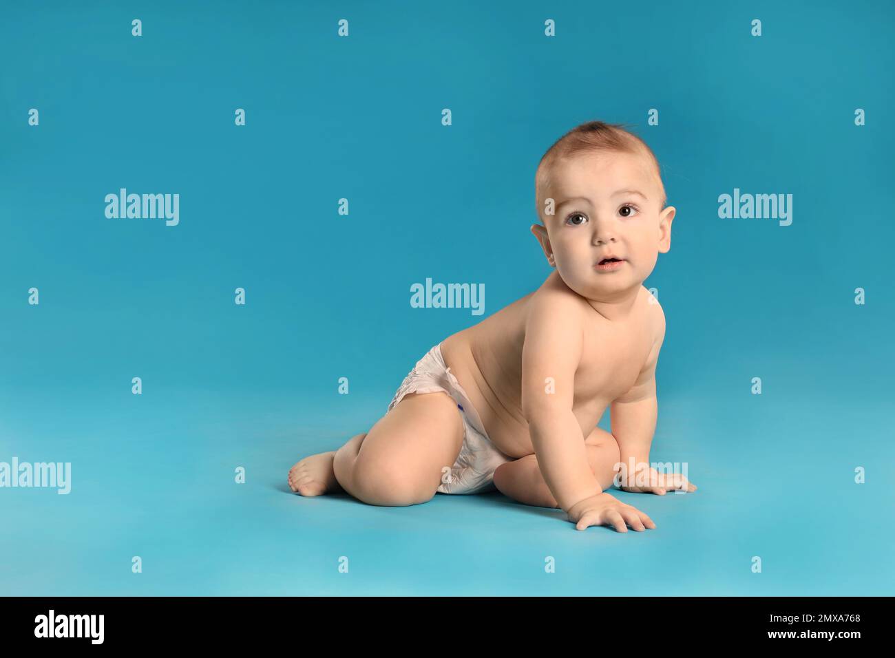 Cute little baby in diaper on light blue background. Space for text ...