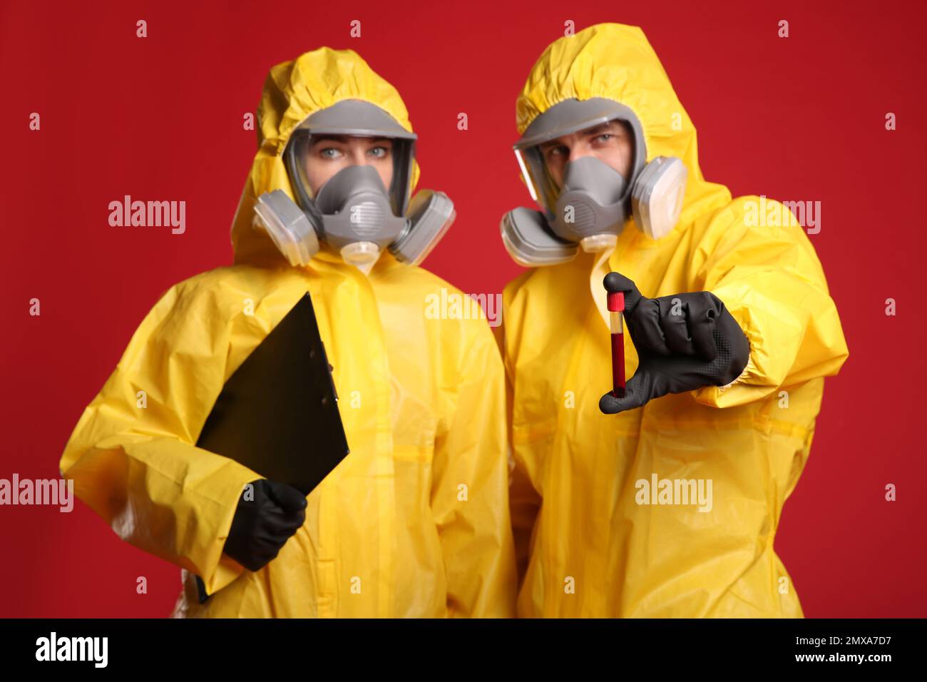 People in chemical protective suits with blood sample and clipboard on ...