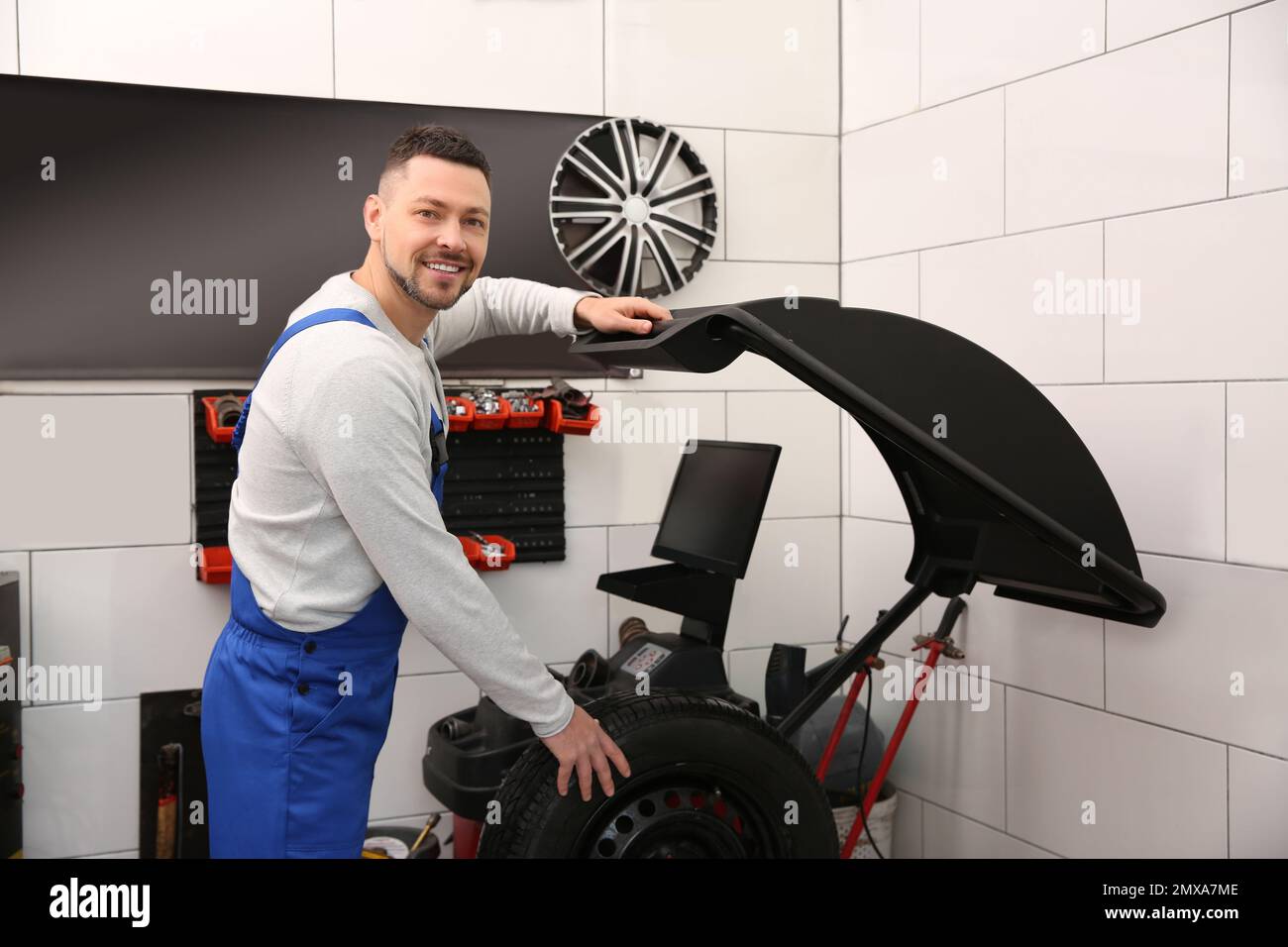 Mechanic working with wheel balancing machine at tire service Stock ...
