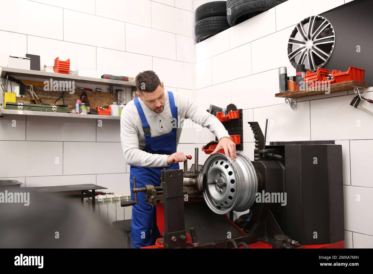 Mechanic working with car disk lathe machine at tire service Stock ...