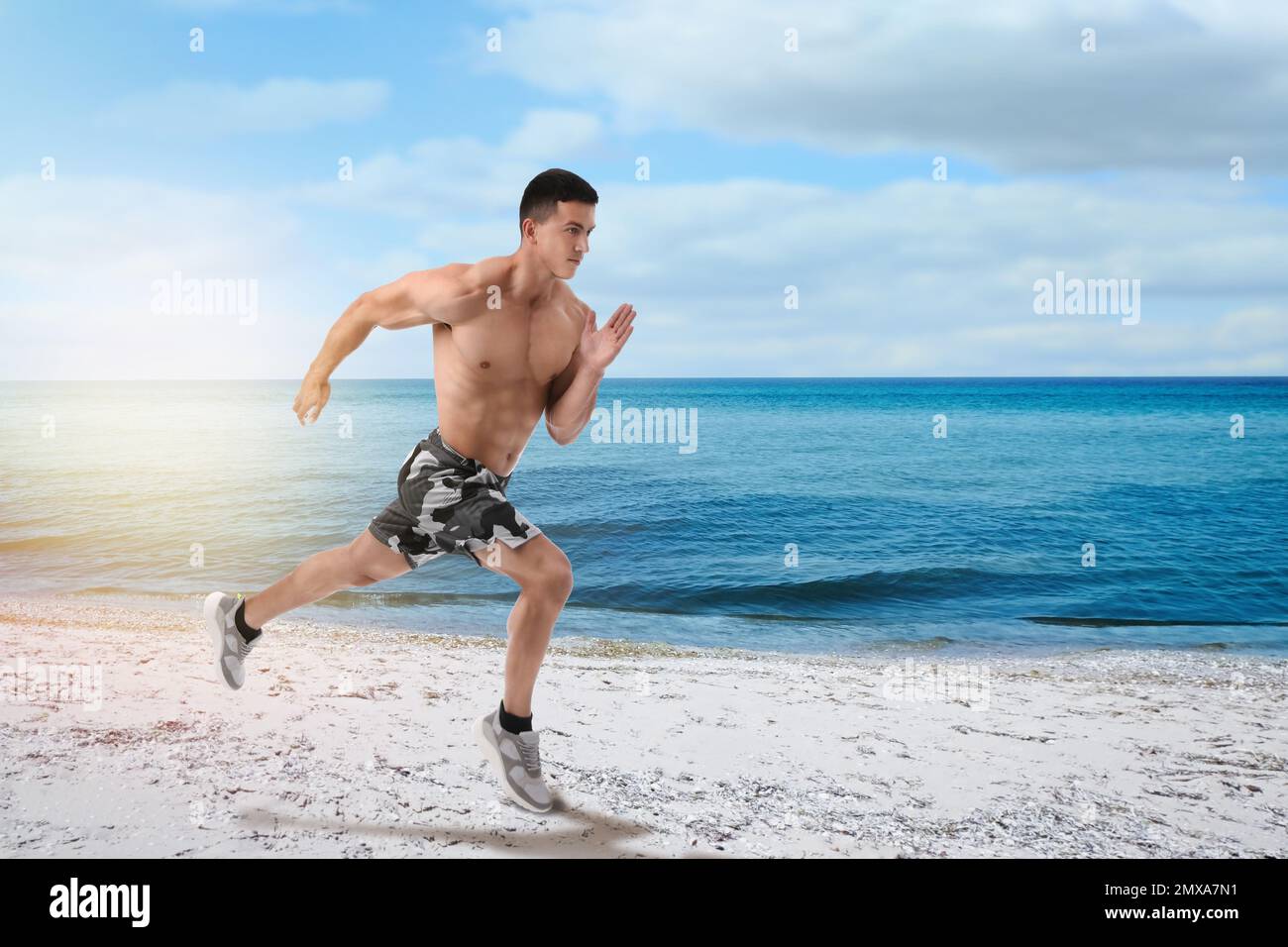 Young man running on sandy beach hi-res stock photography and images ...