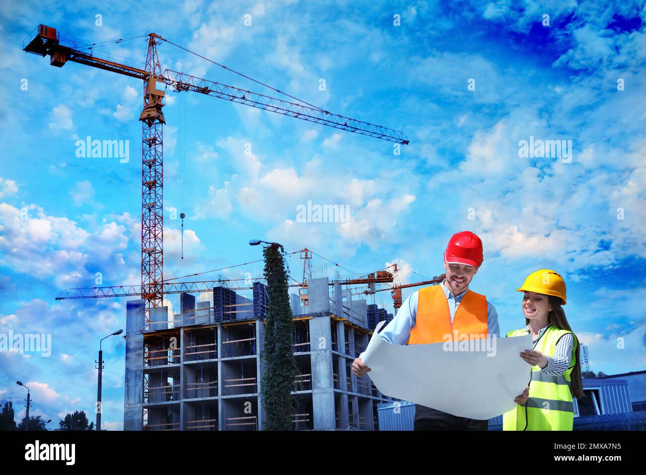 Professional engineers in safety equipment with drafting at ...