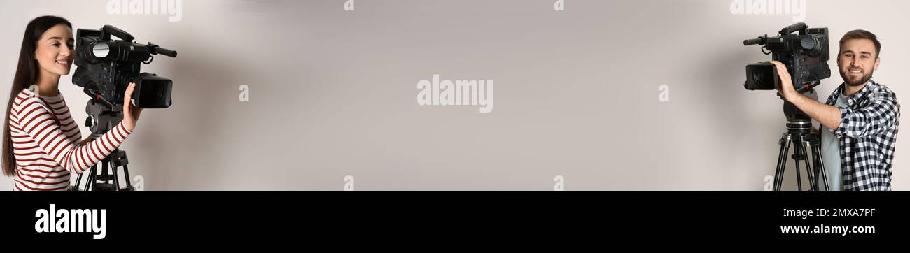 Operators with professional video cameras on light background, space ...