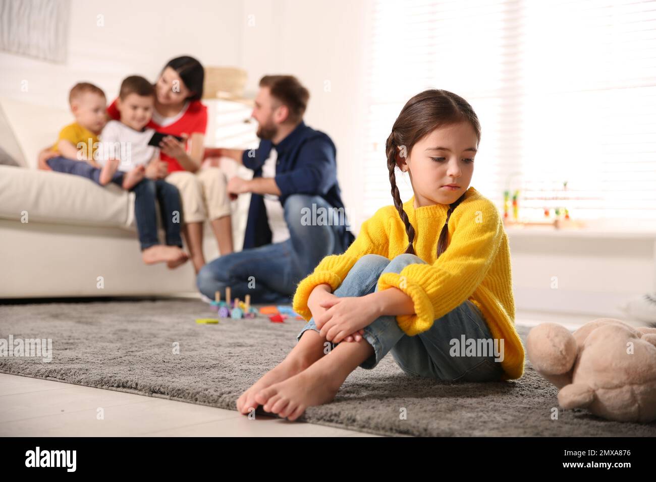 Unhappy little girl feeling jealous while parents spending time with ...