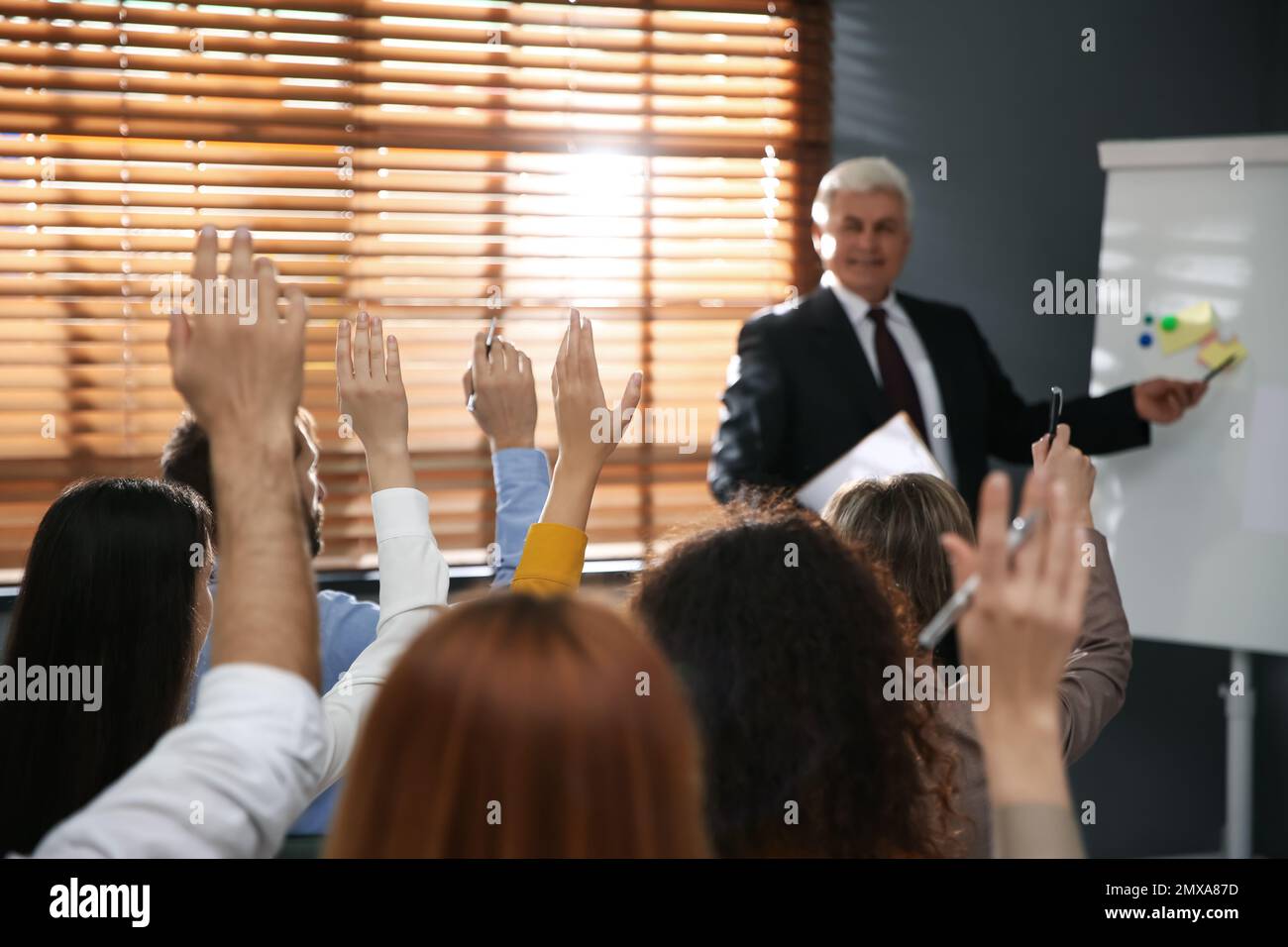 People raising hands to ask questions at seminar in office Stock Photo ...
