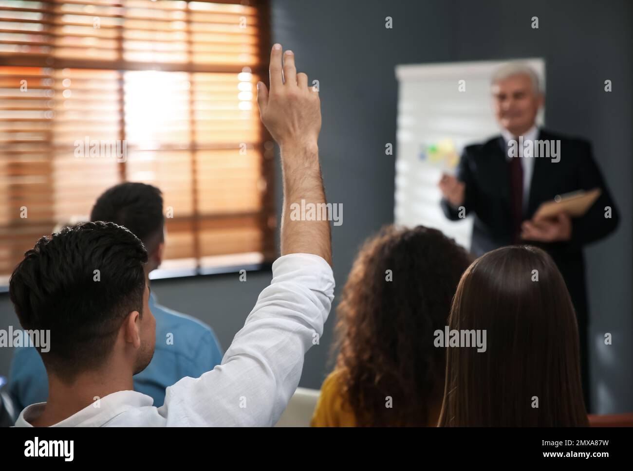People raising hands to ask questions at seminar in office Stock Photo ...