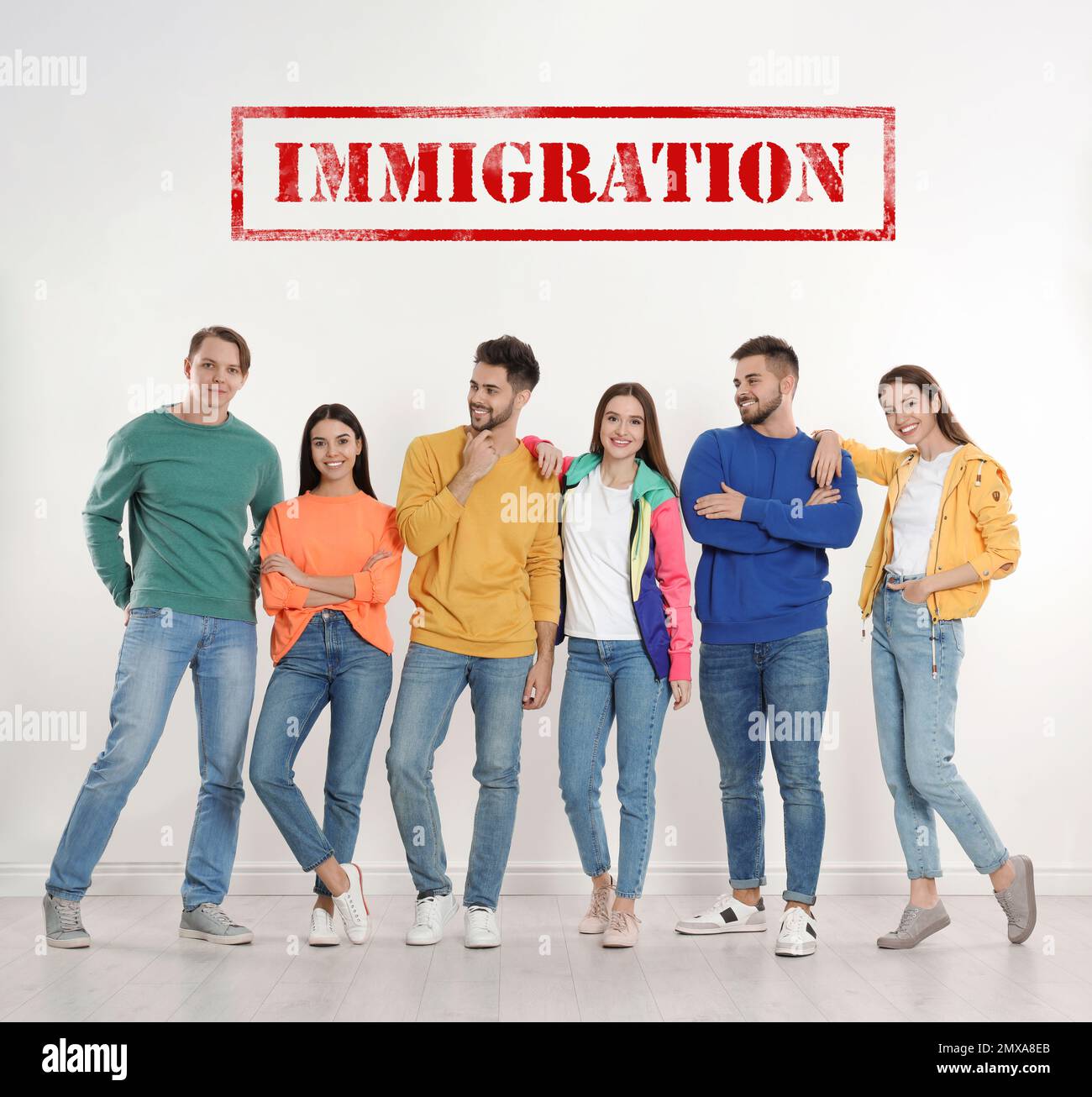 Immigration concept. Group of young people standing near light wall ...