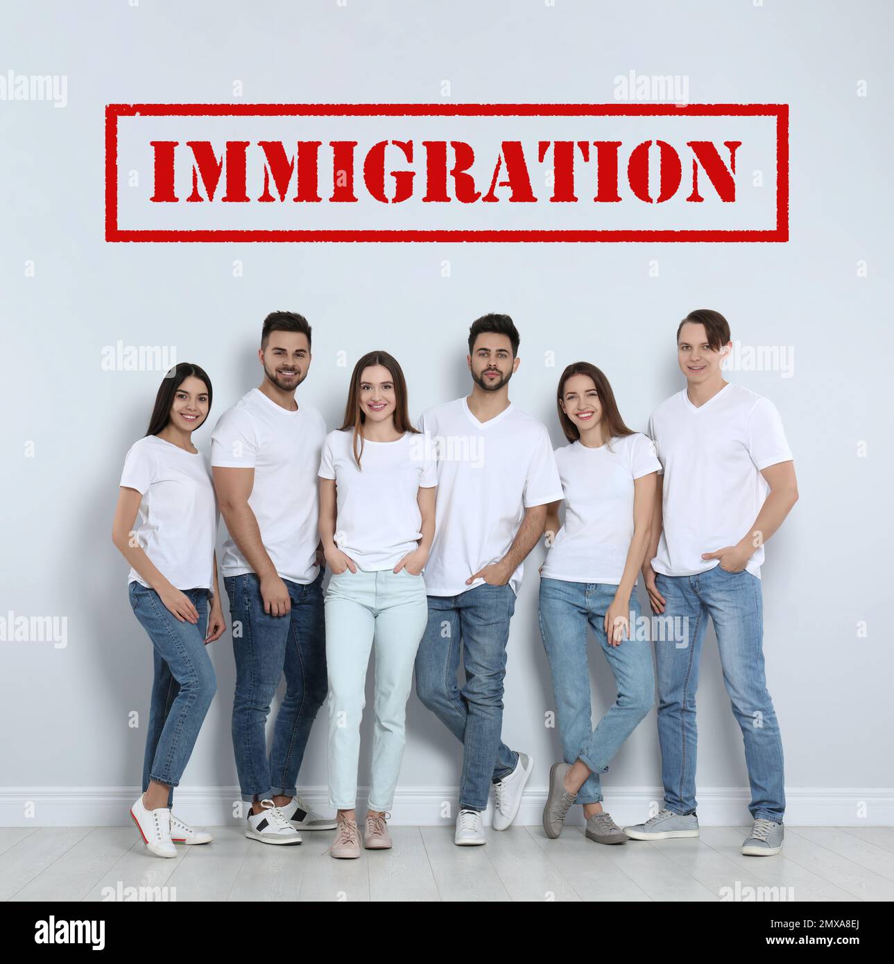 Immigration concept. Group of young people standing near light wall ...