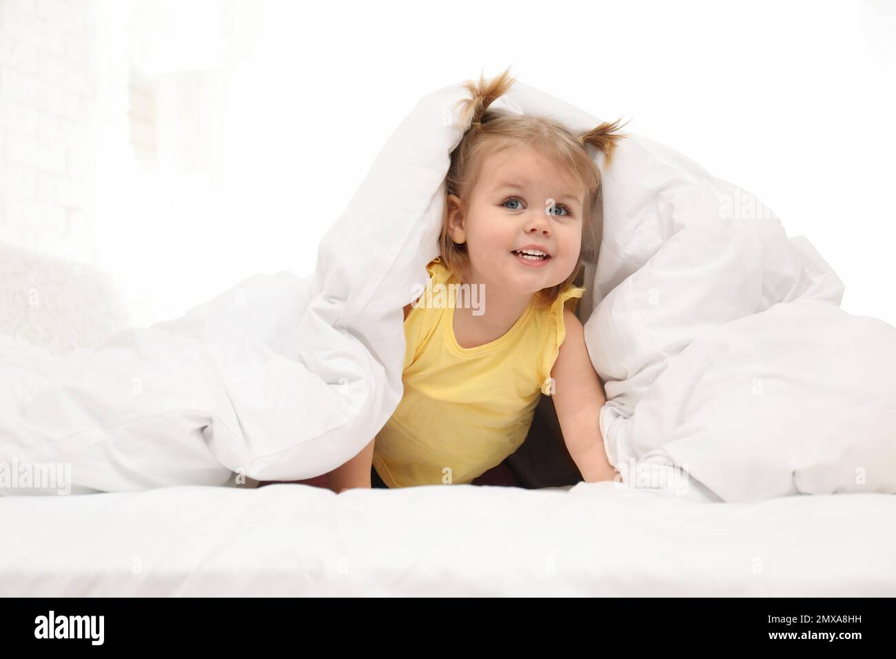 Cute little child playing under blanket in bed Stock Photo - Alamy