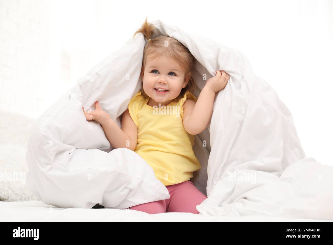 Cute little child playing under blanket in bed Stock Photo - Alamy