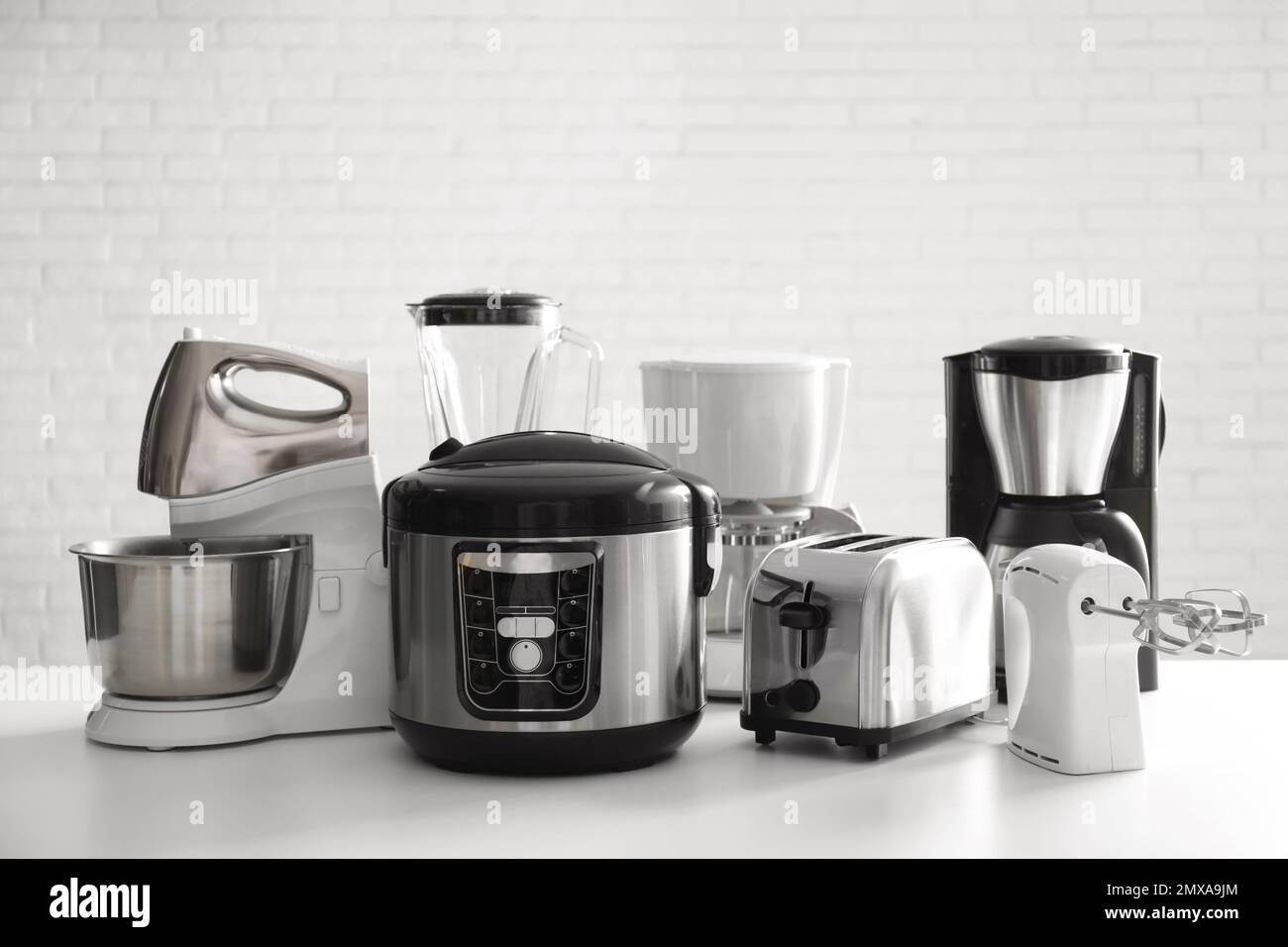 Set of modern home appliances on white table Stock Photo - Alamy