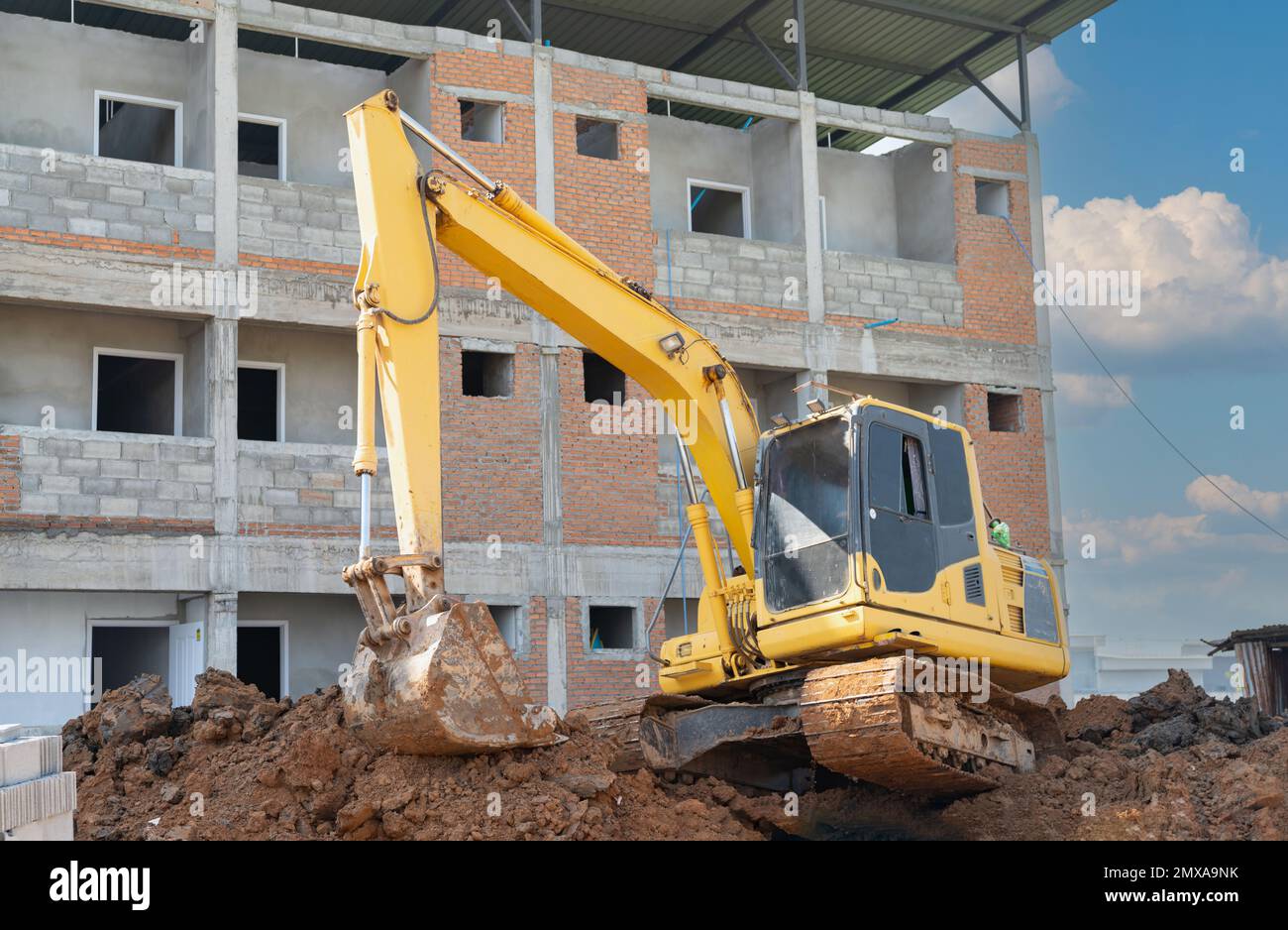 Backhole loader digging drainage ditch and laying concrete pipeline in ...