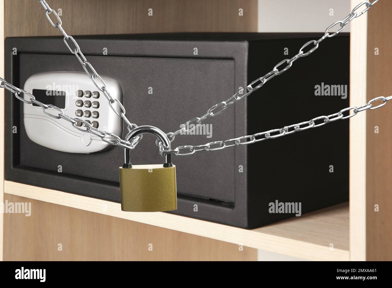Padlock, chains and black steel safe in wooden closet Stock Photo - Alamy
