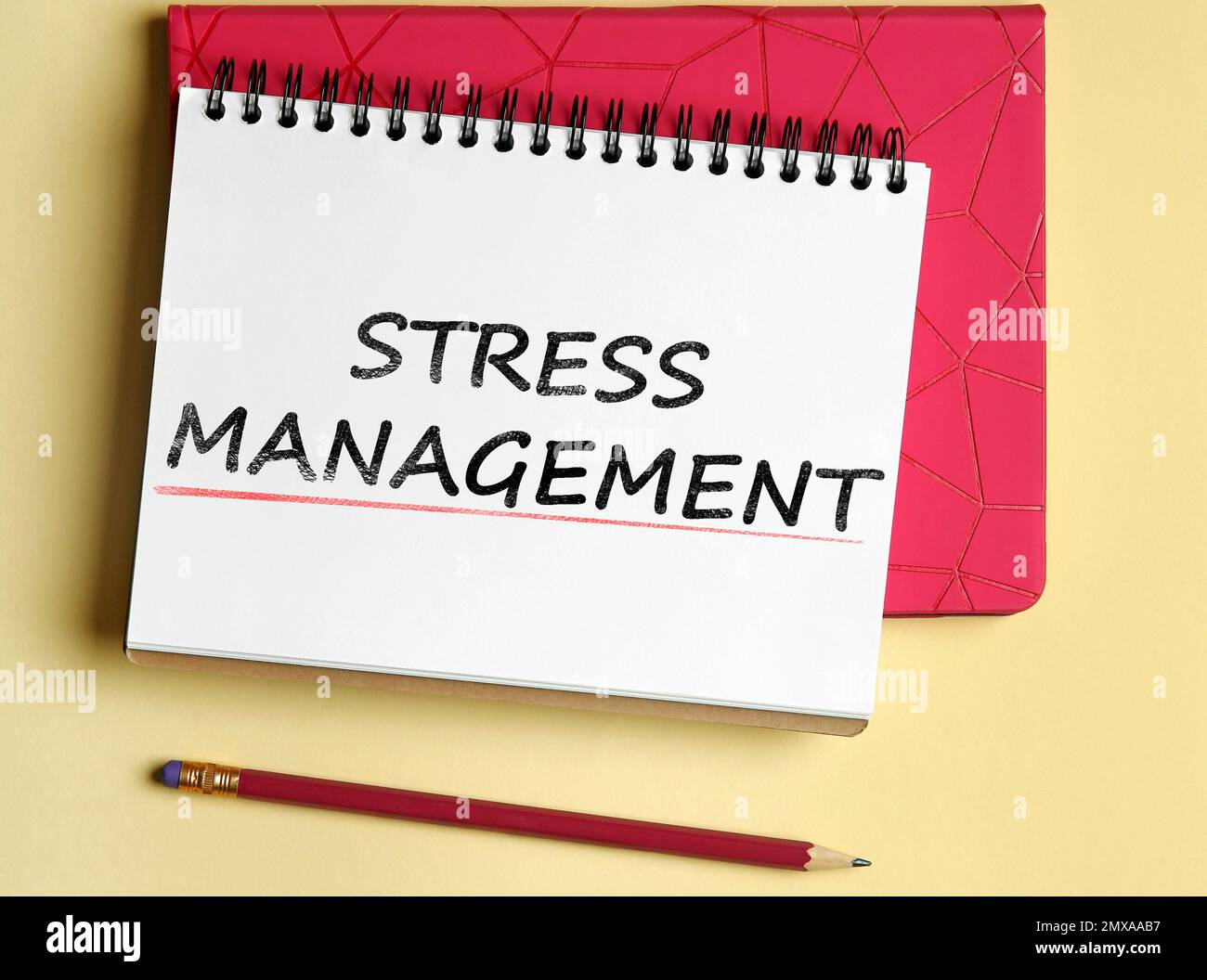 Notepad with text STRESS MANAGEMENT and pencil on beige background ...