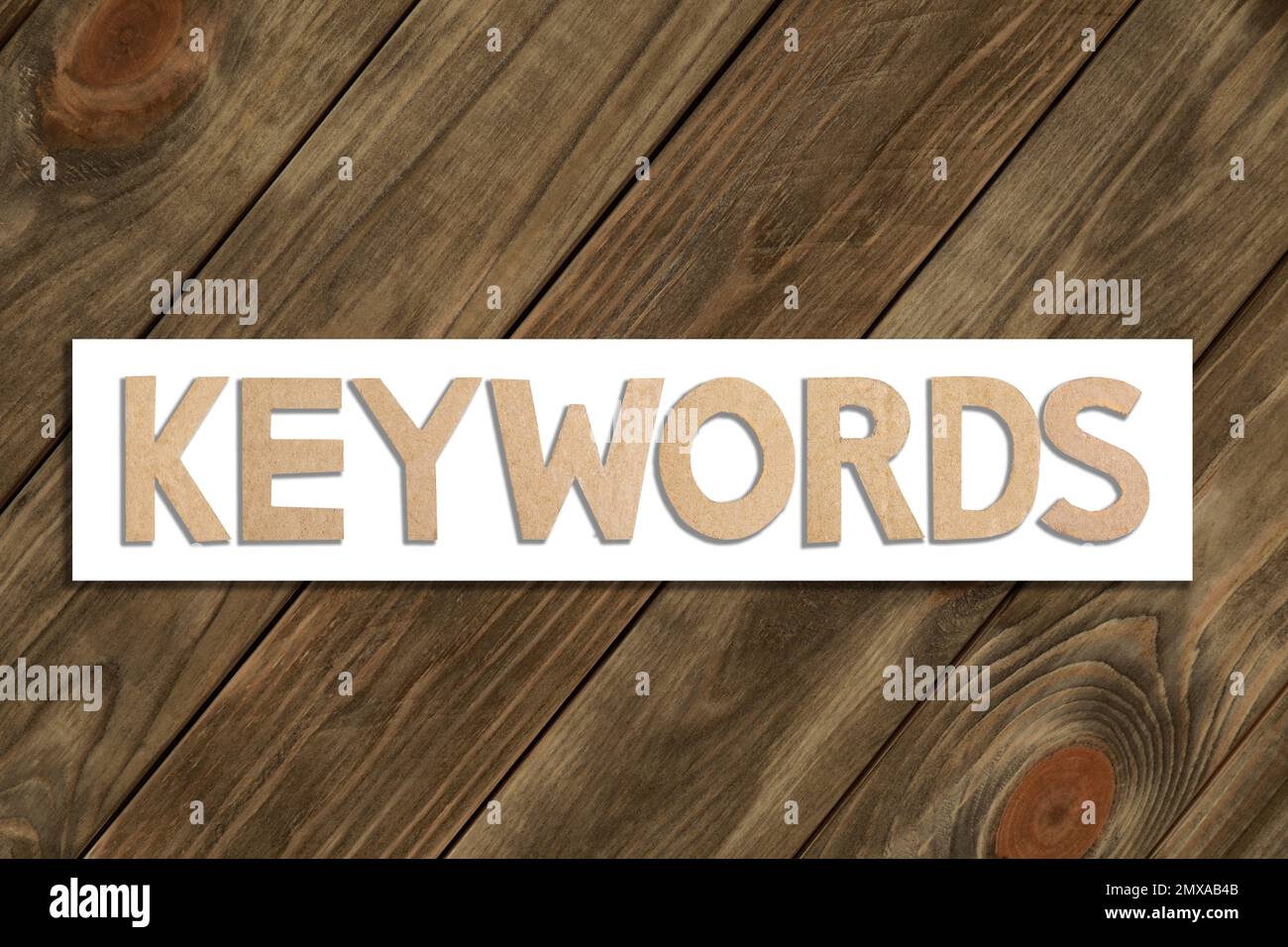 Text KEYWORDS made of cardboard on wooden background Stock Photo - Alamy