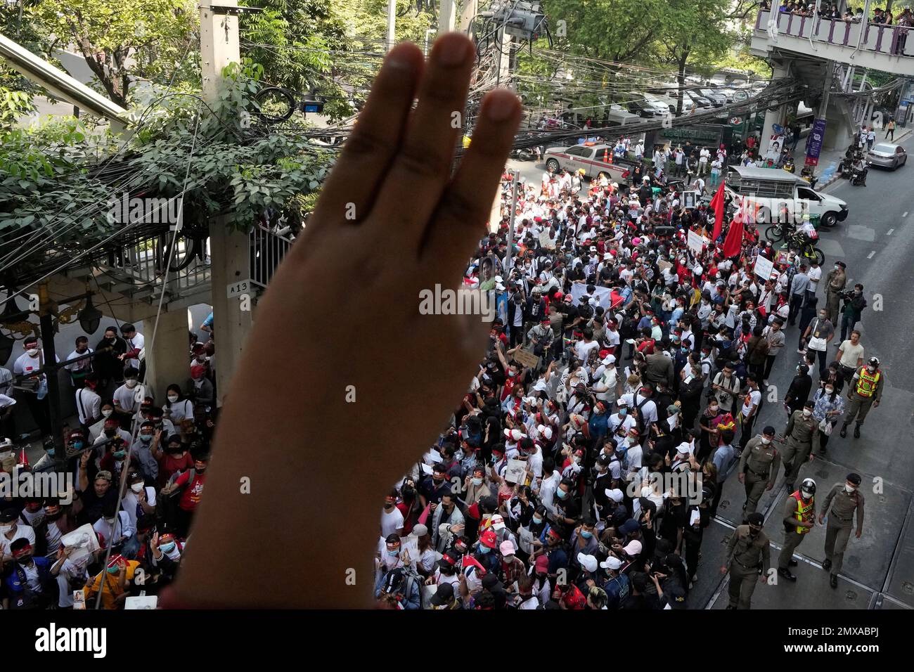 Myanmar nationals living in Thailand display the three-finger symbol of ...