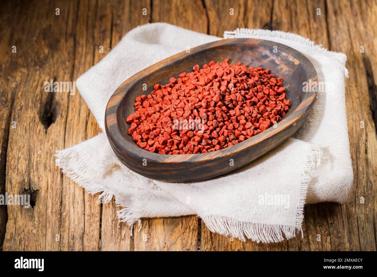 Achiote grains in container, typical condiment of South America, close ...