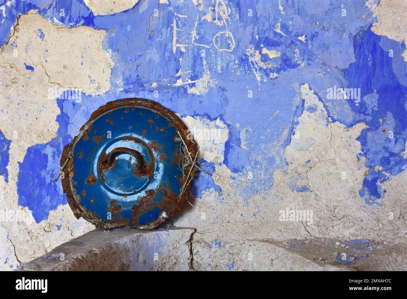 Rusty blue lid of cooking pot in front of blue peeled wall, Spain Stock ...
