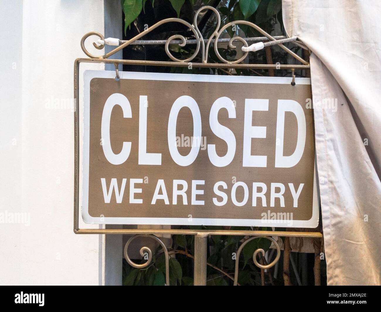 Metal sign saying: Closed. We are sorry. On brown background Stock ...