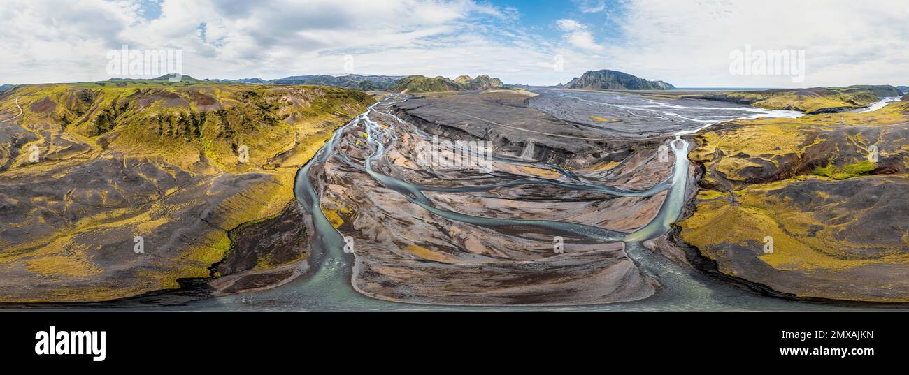 River with fanned out branches through black lava sand, moss-covered ...