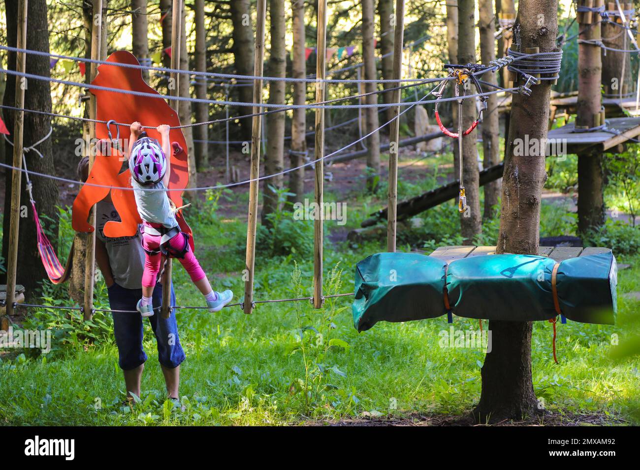 Child, girl with helmet, forest ropes course, climbing park, high ropes ...