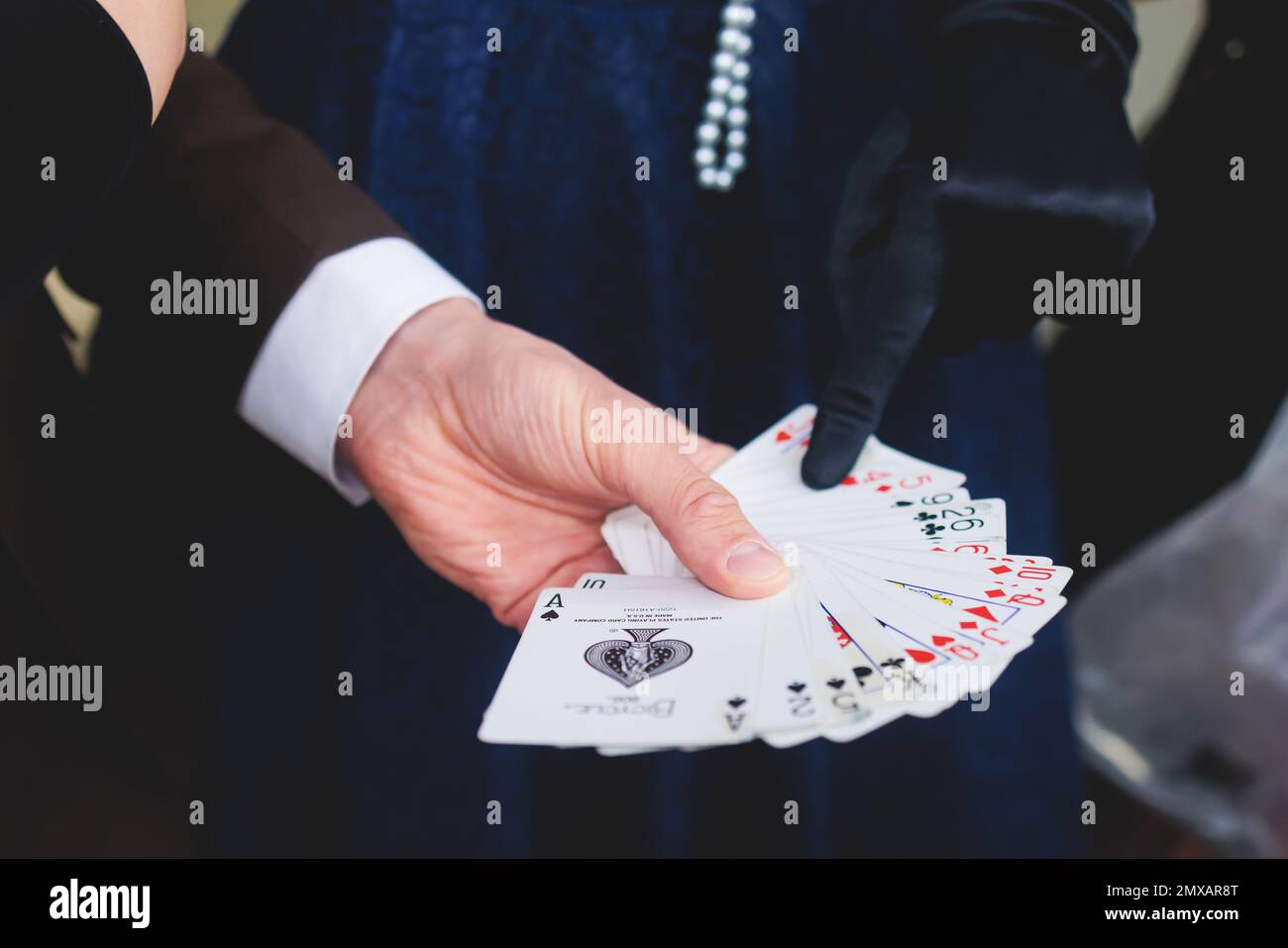 Magician illusionist with a deck of cards showing card tricks focus in ...