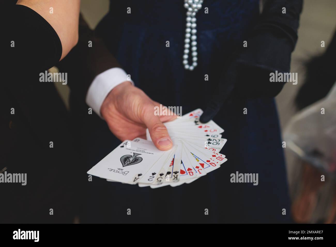 Magician illusionist with a deck of cards showing card tricks focus in ...