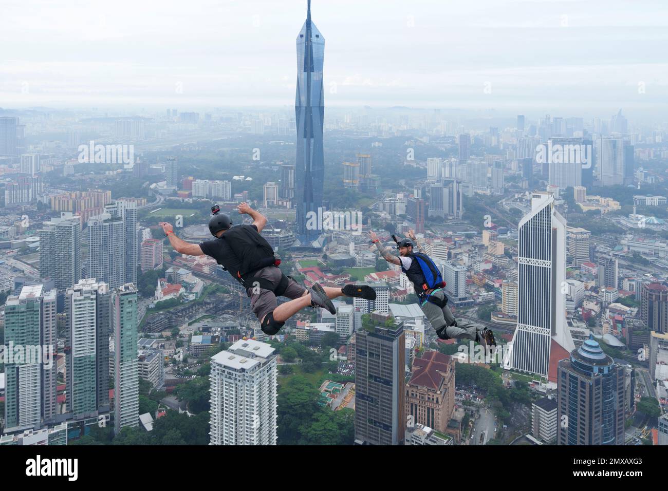 A pair of BASE jumpers dive from the Kuala Lumpur Tower during the KL Tower International Jump ...