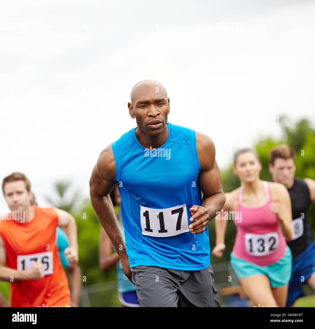 The leader of the pack. Front view of a male runner in first place with ...