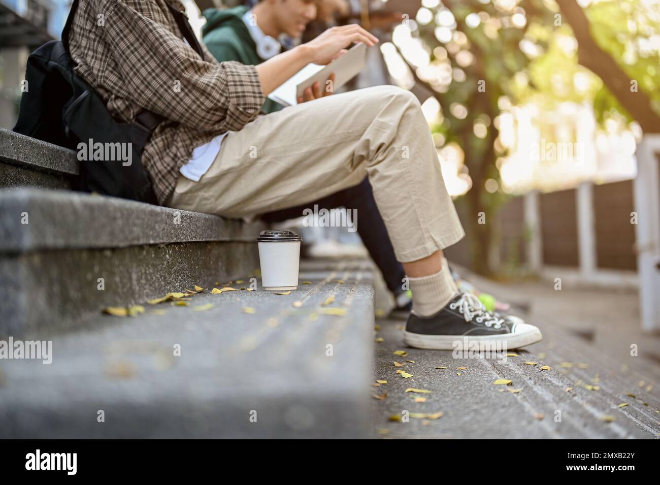 Side view of a young Asian male college student in casual clothes ...