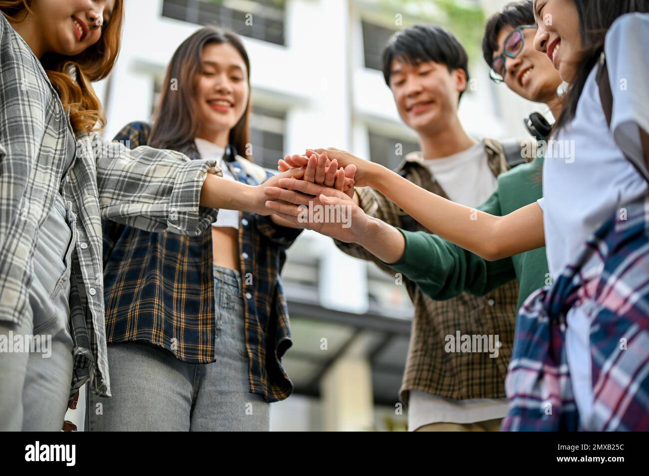 Group of cheerful young Asian college students putting their hands ...
