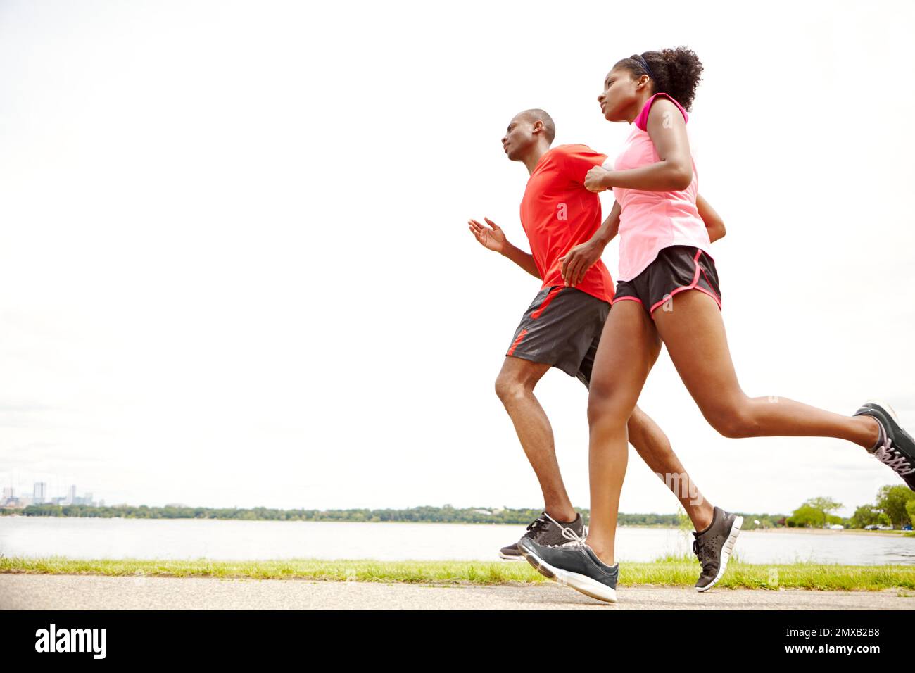 Serene jogging. Full length side view of two athletes running next to a ...