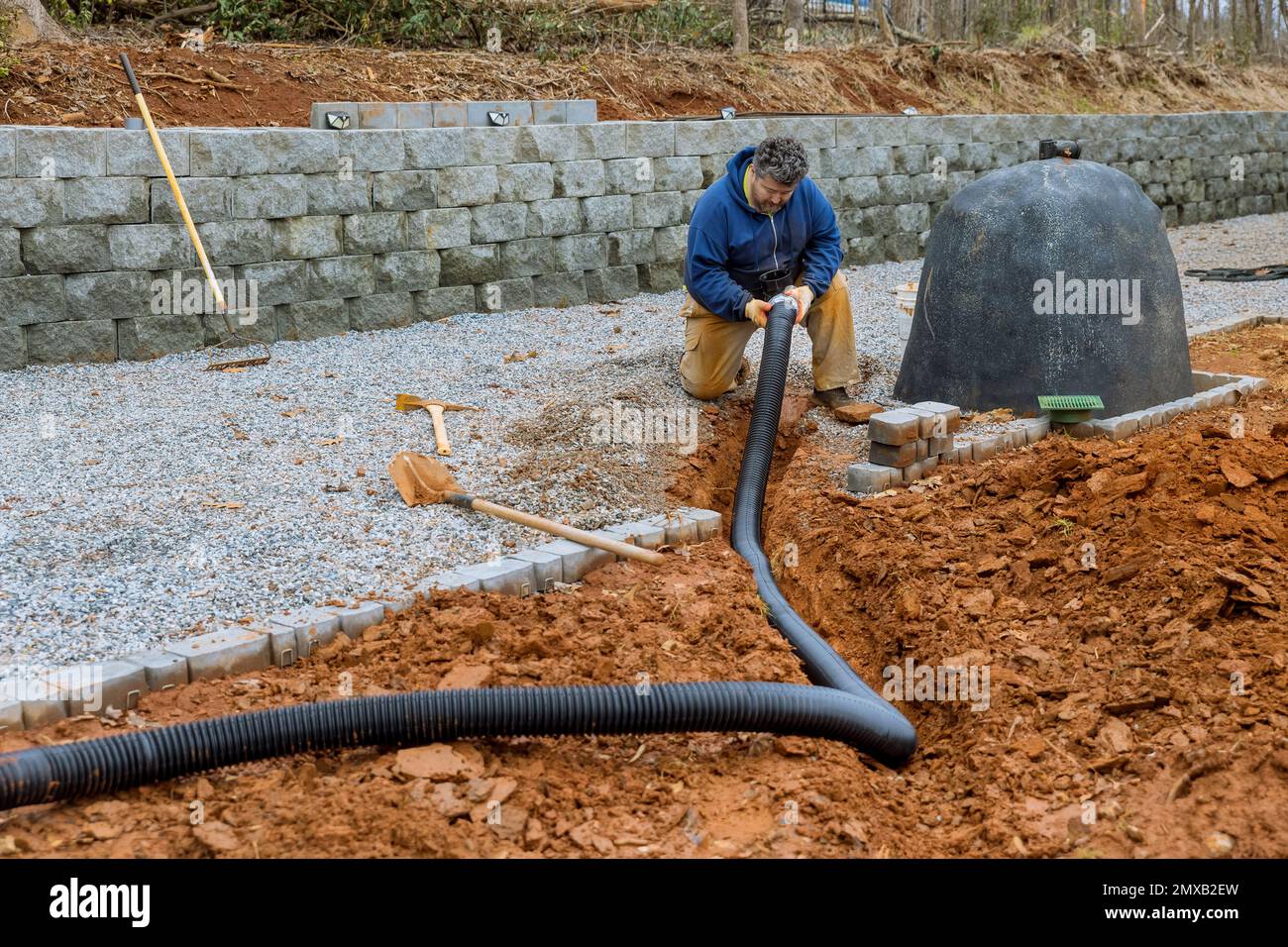 Laying drainage pipe for rain water on car parking lot is covered ...