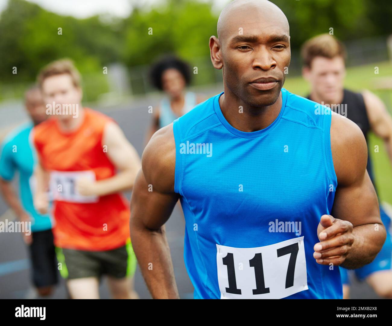 His goal is in sight. Front view of a male runner looking determined ...